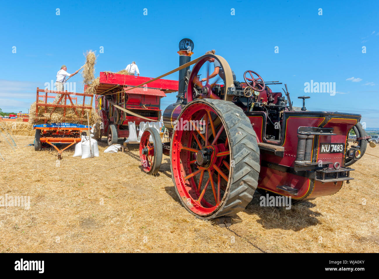 A threshing machine being powered by a traction engine at the 2018 Low ...
