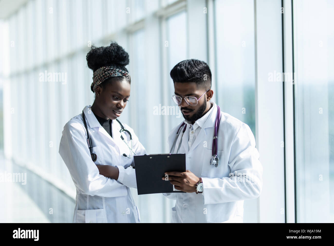Portrait of doctors looking at a document in an office Stock Photo - Alamy