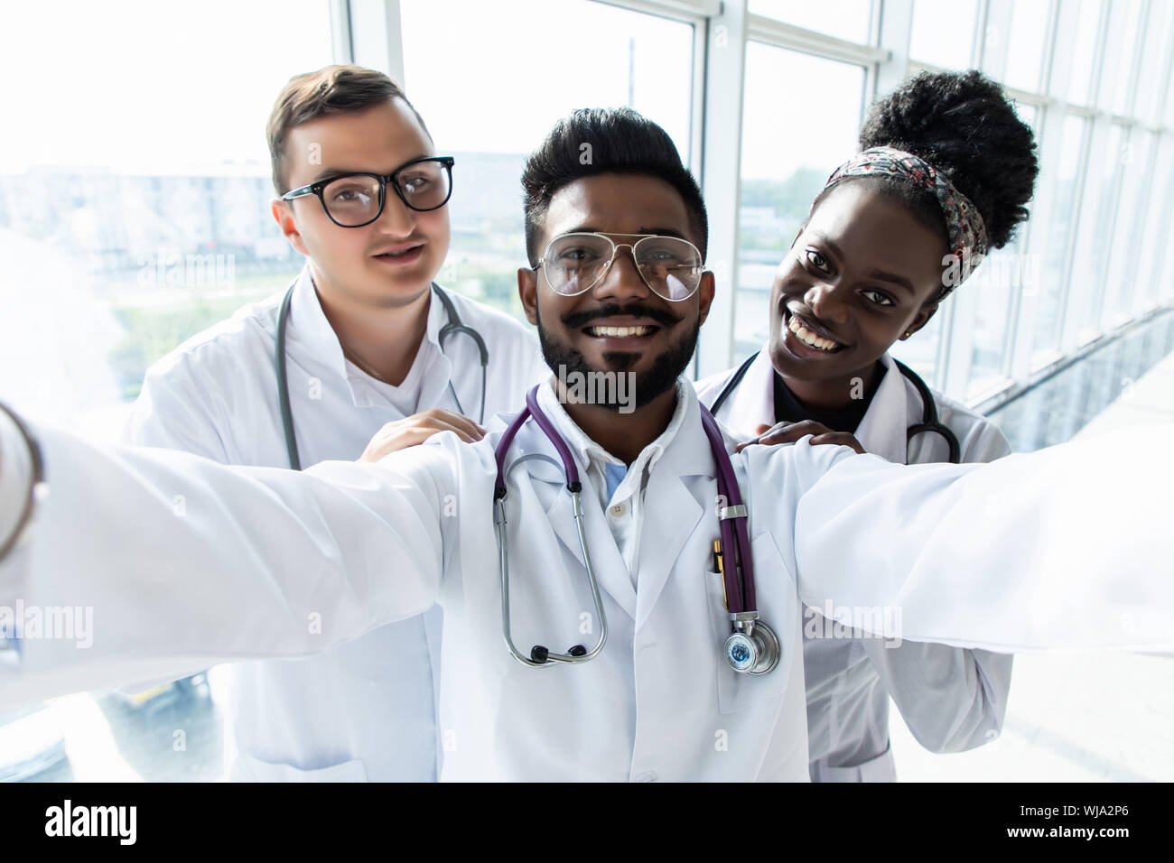 group of doctors interns taking selfies in the lobby of the hospital ...