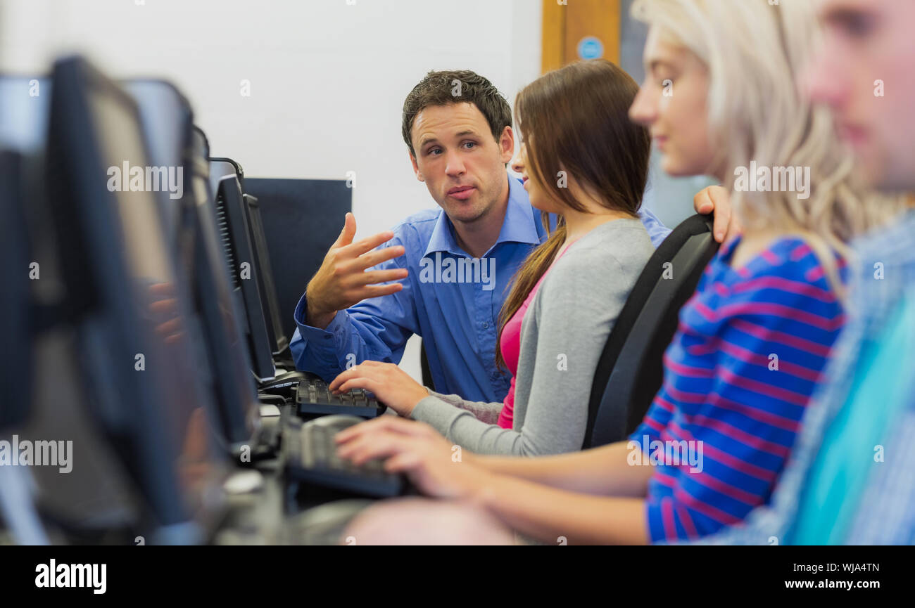 Teacher explaining to young college students in the computer room Stock ...