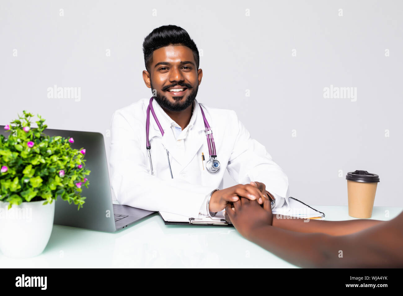 Male doctor and patient in discussion at desk in medical office Stock ...