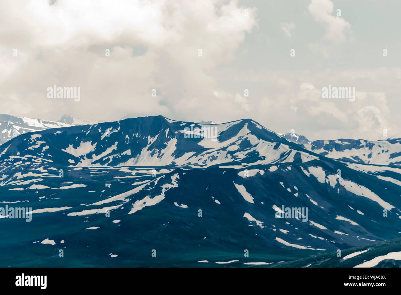 Snowy blue mountain peak background Stock Photo - Alamy