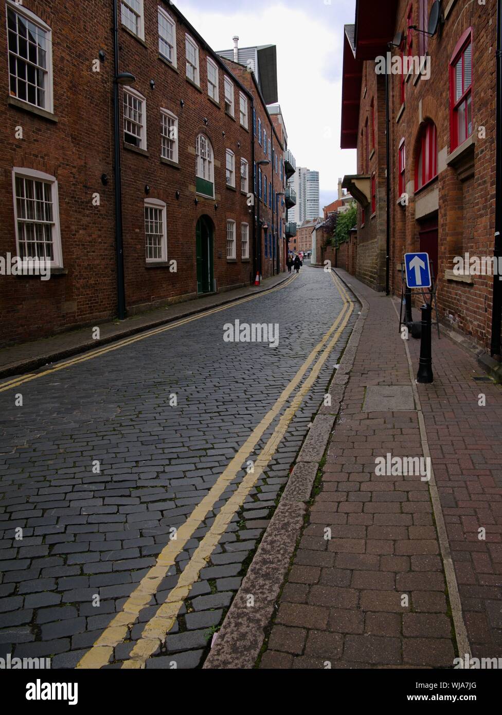 Cobbled narrow back street in Leeds with red brick buildings each side ...