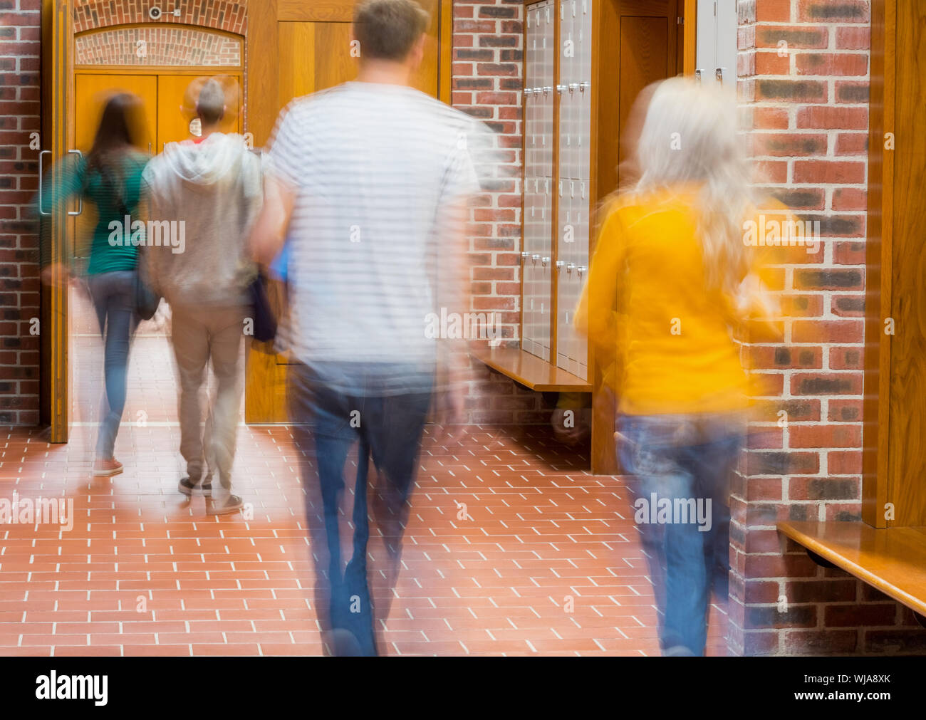 Group of blurred college students walking through corridor Stock Photo ...