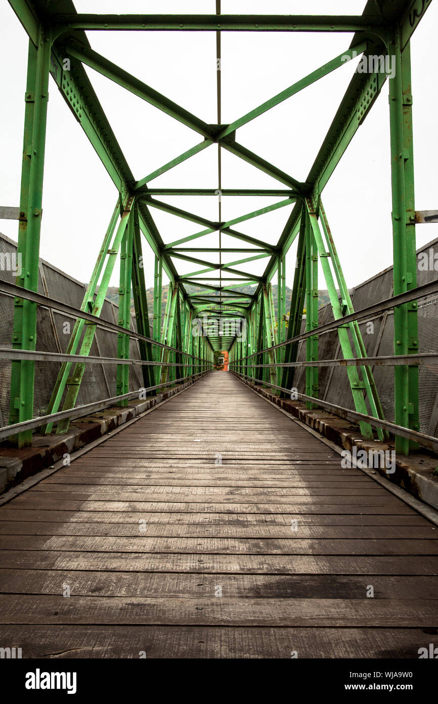 Narrow long footbridge with symmetrical metal structure Stock Photo - Alamy