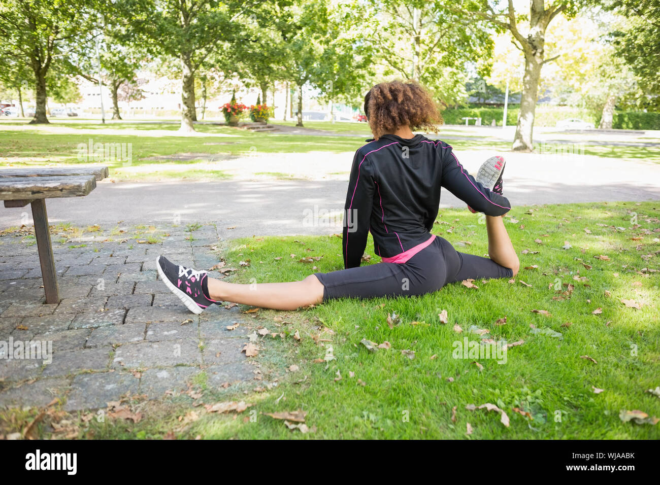 Rear view of a flexible young woman doing the splits exercise in the ...