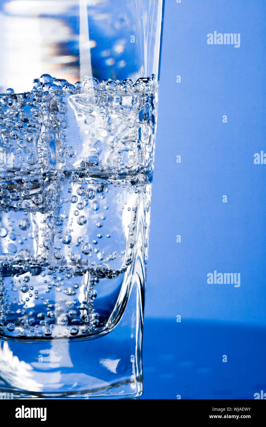 glass with cold water on blue background Stock Photo - Alamy