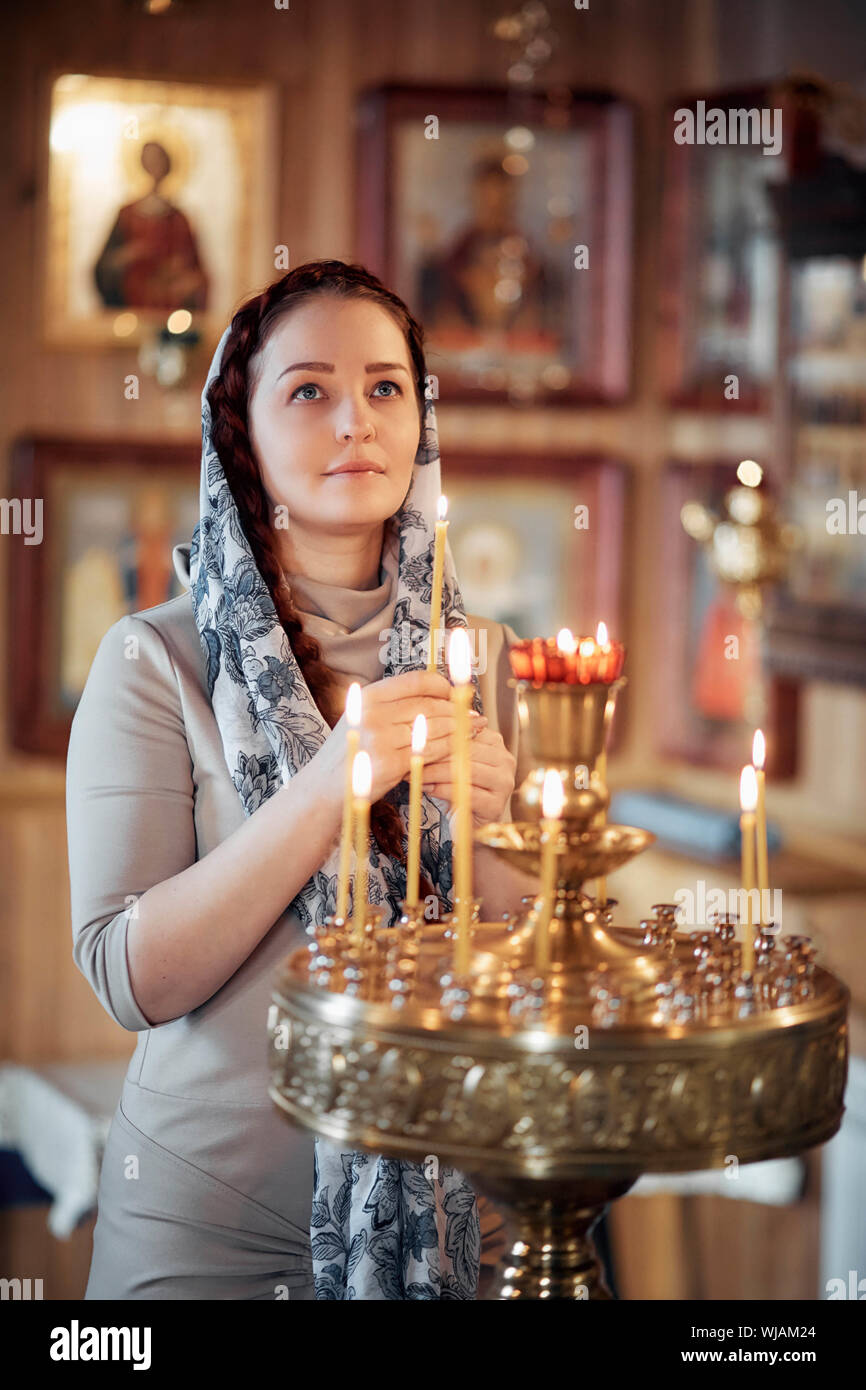 woman in the Russian Orthodox Church with red hair and a scarf on her ...