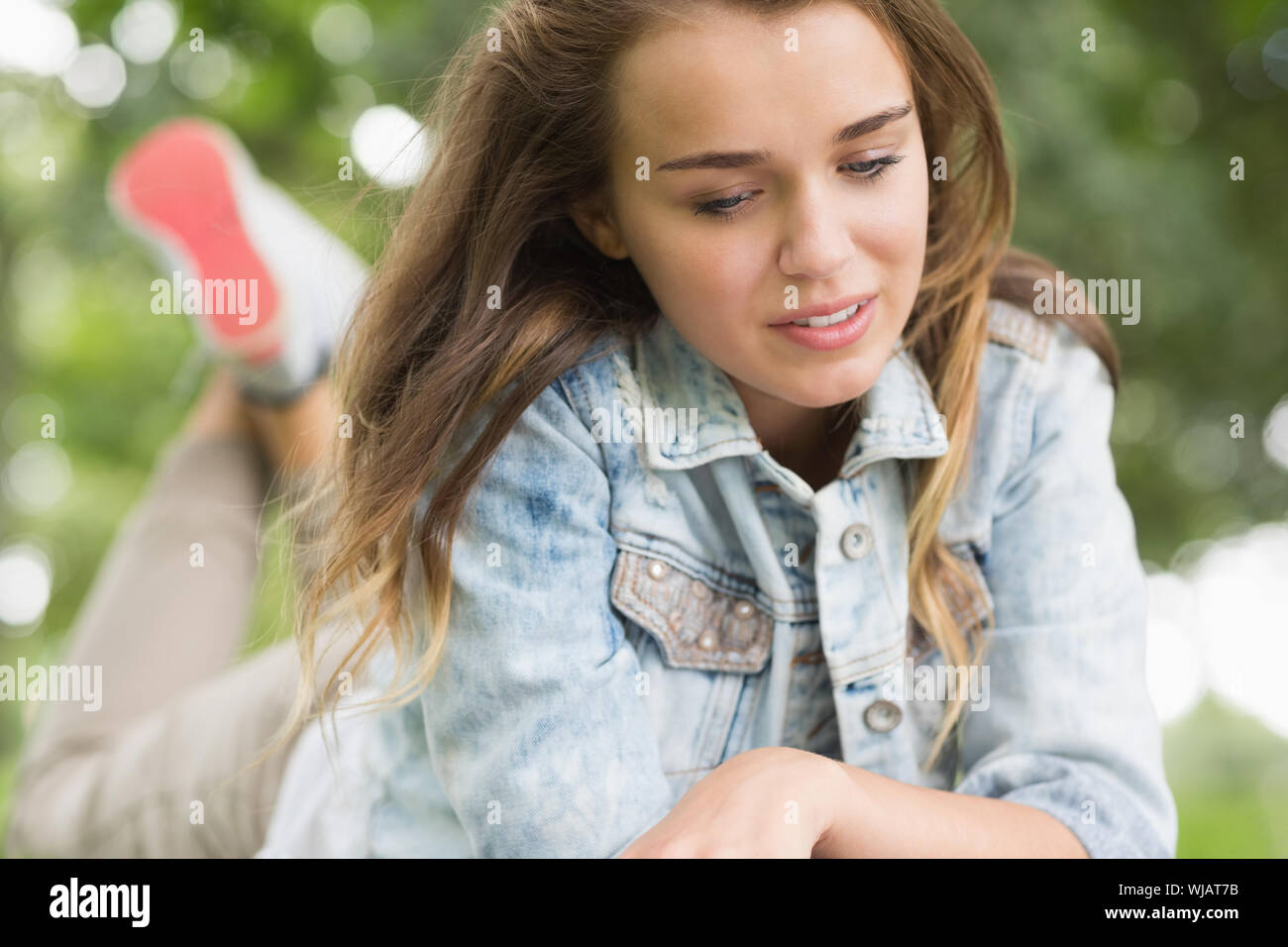 Pretty young girl lying on grass Stock Photo - Alamy