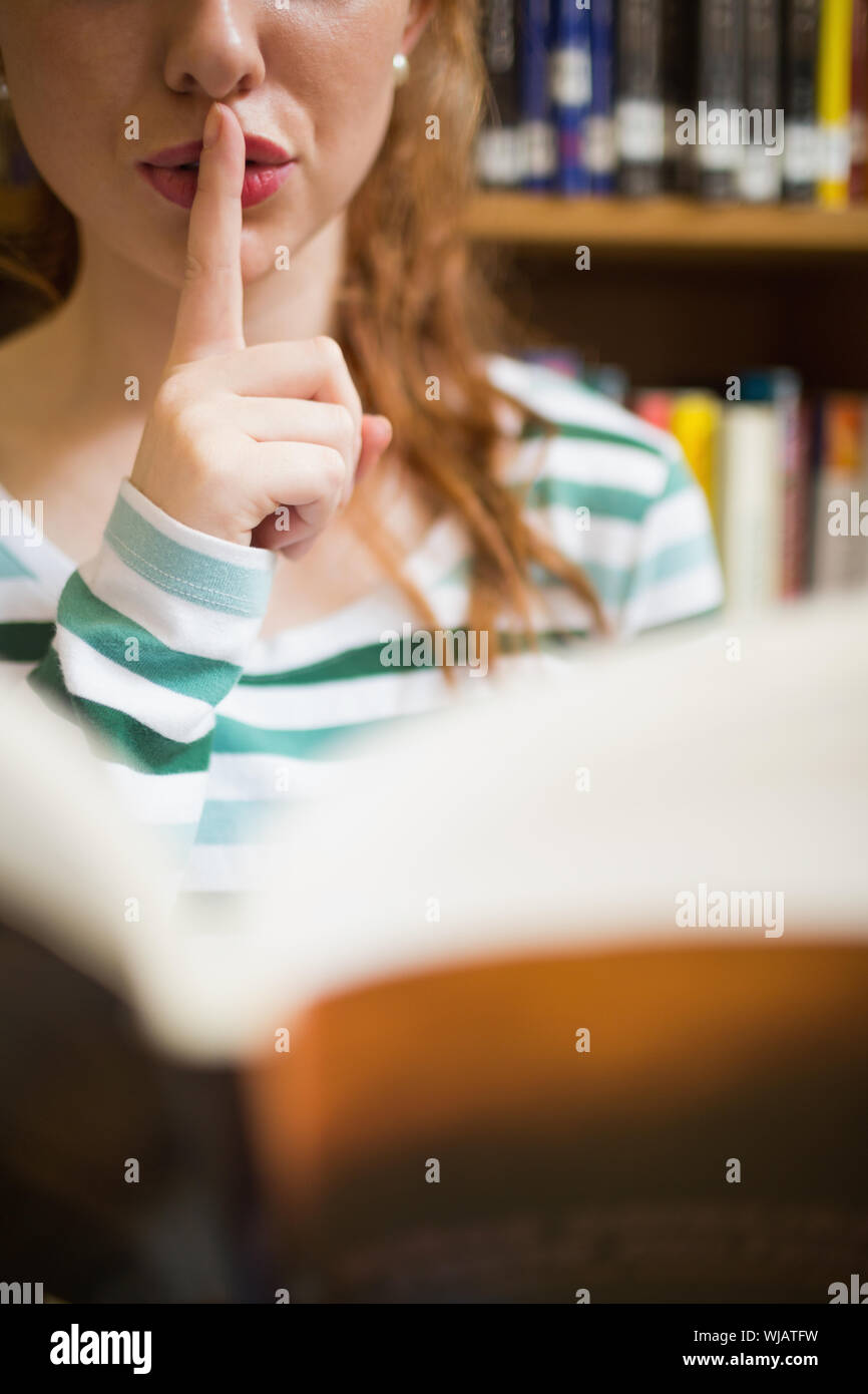 Student asking for silence holding a book Stock Photo - Alamy