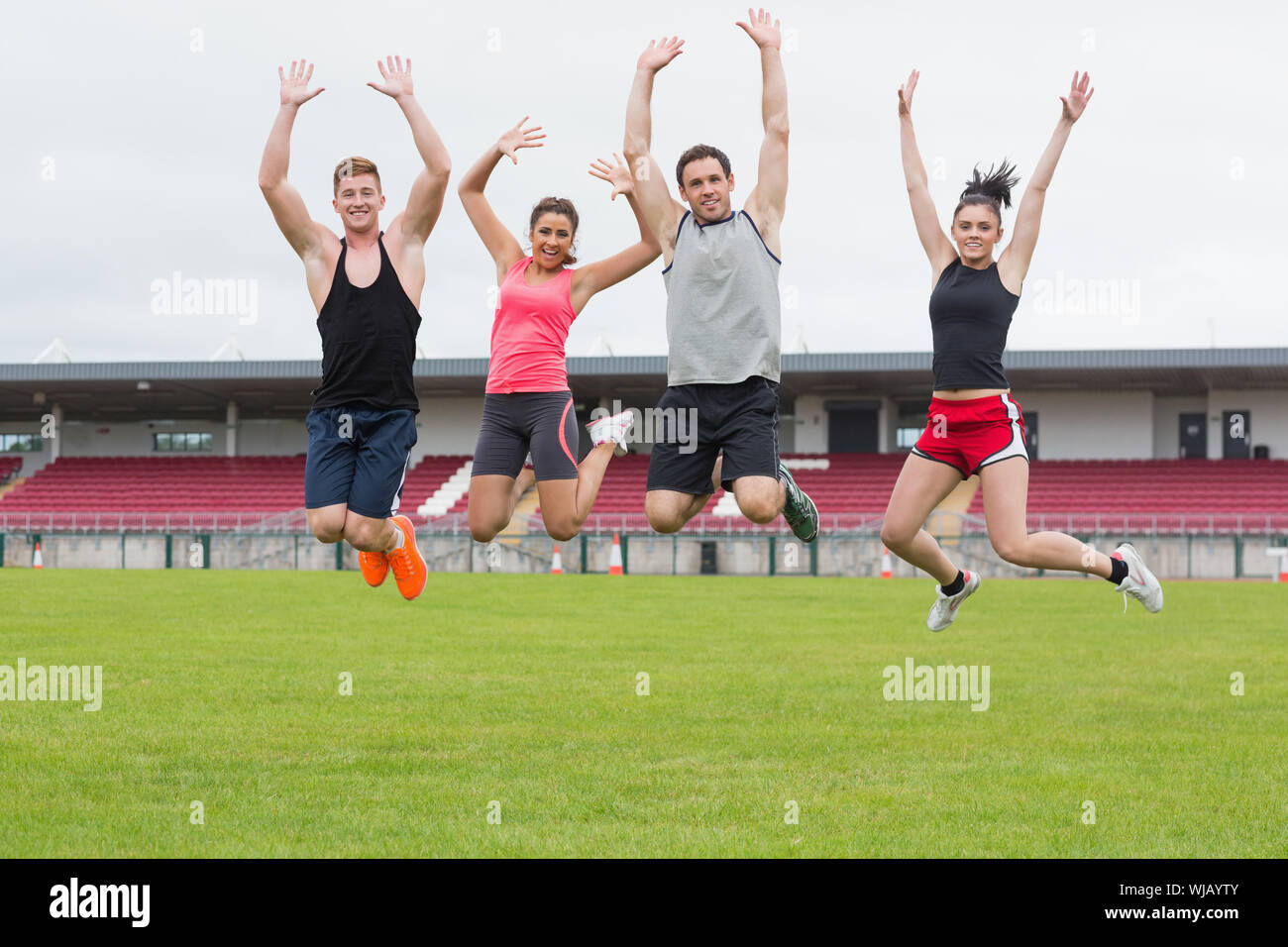Fit people jumping on ground against the stadium Stock Photo - Alamy