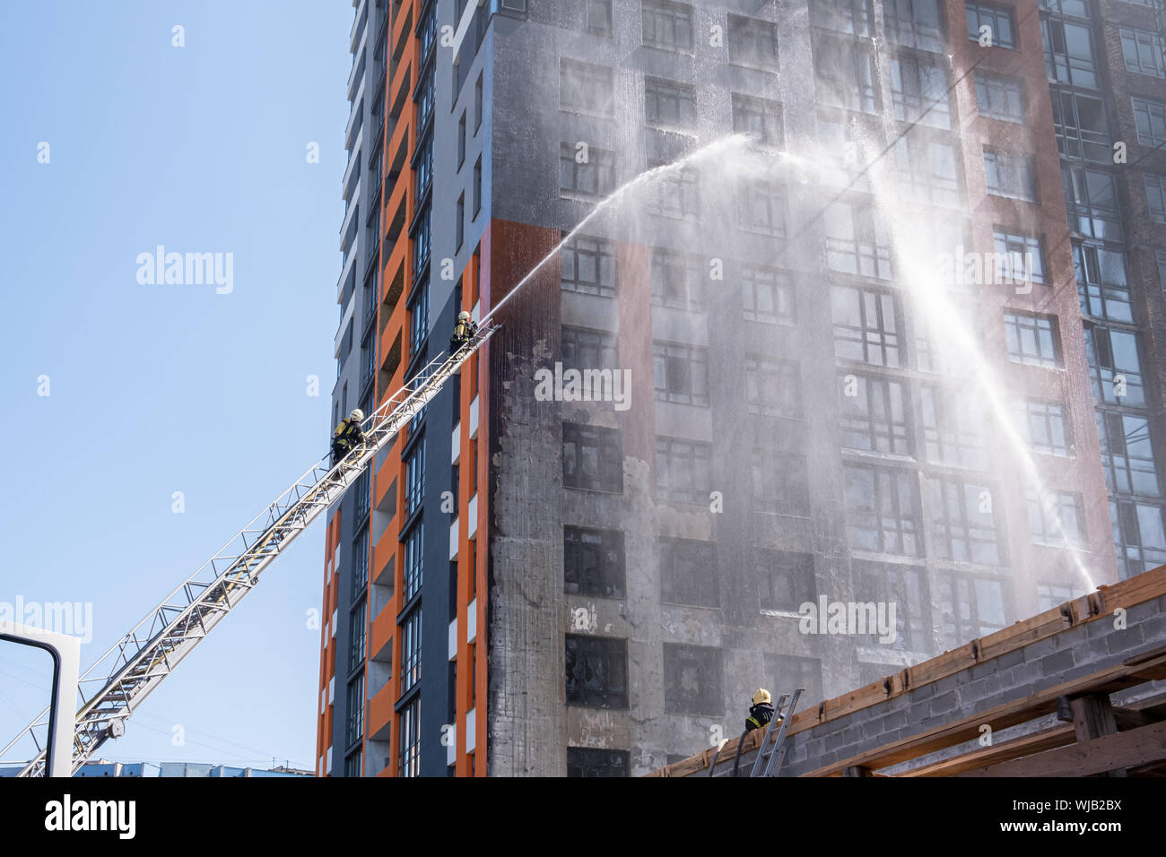 fireman climbing a ladder with water hose for extinguish fire ...