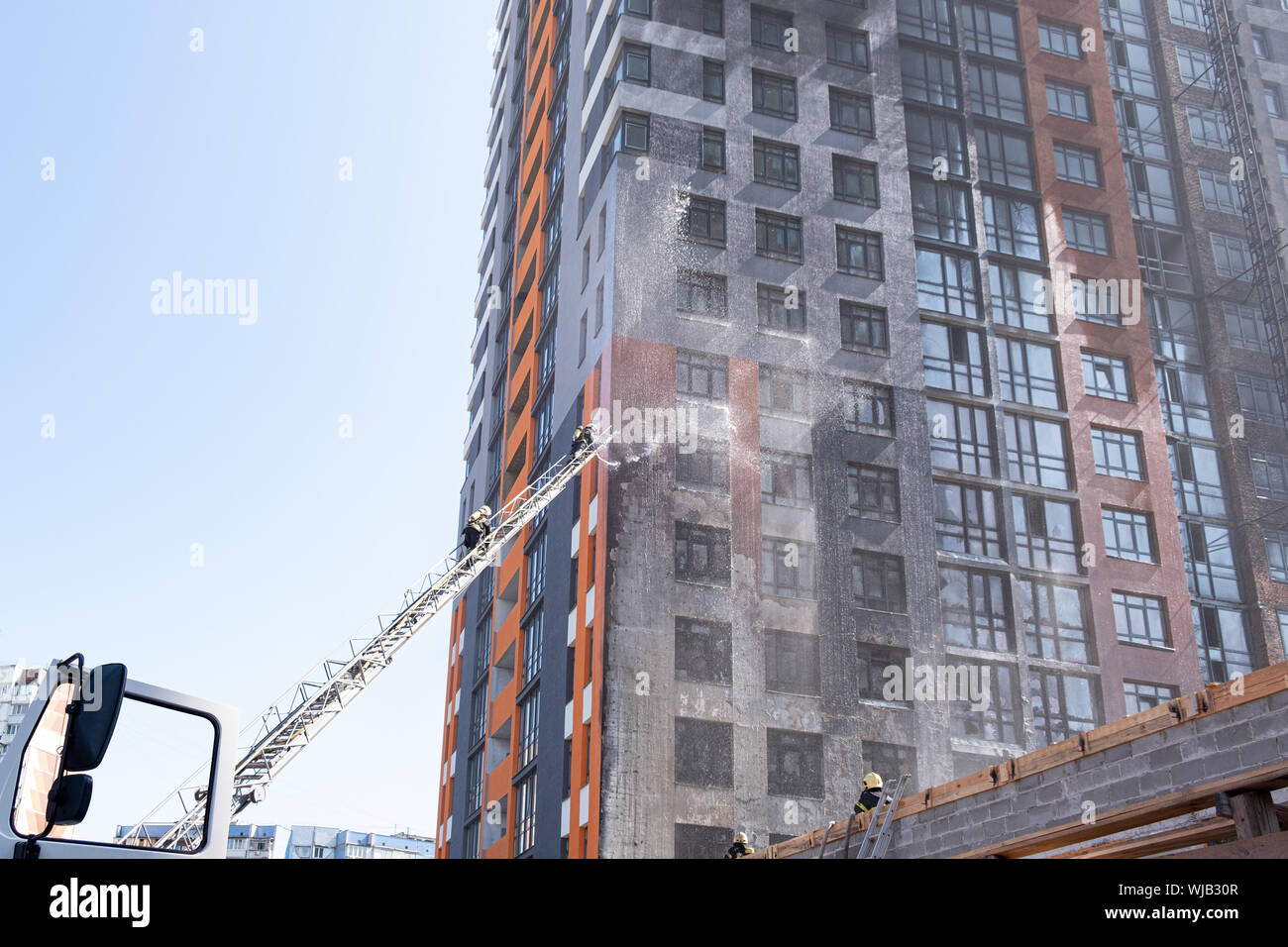 fireman climbing a ladder with water hose for extinguish fire ...