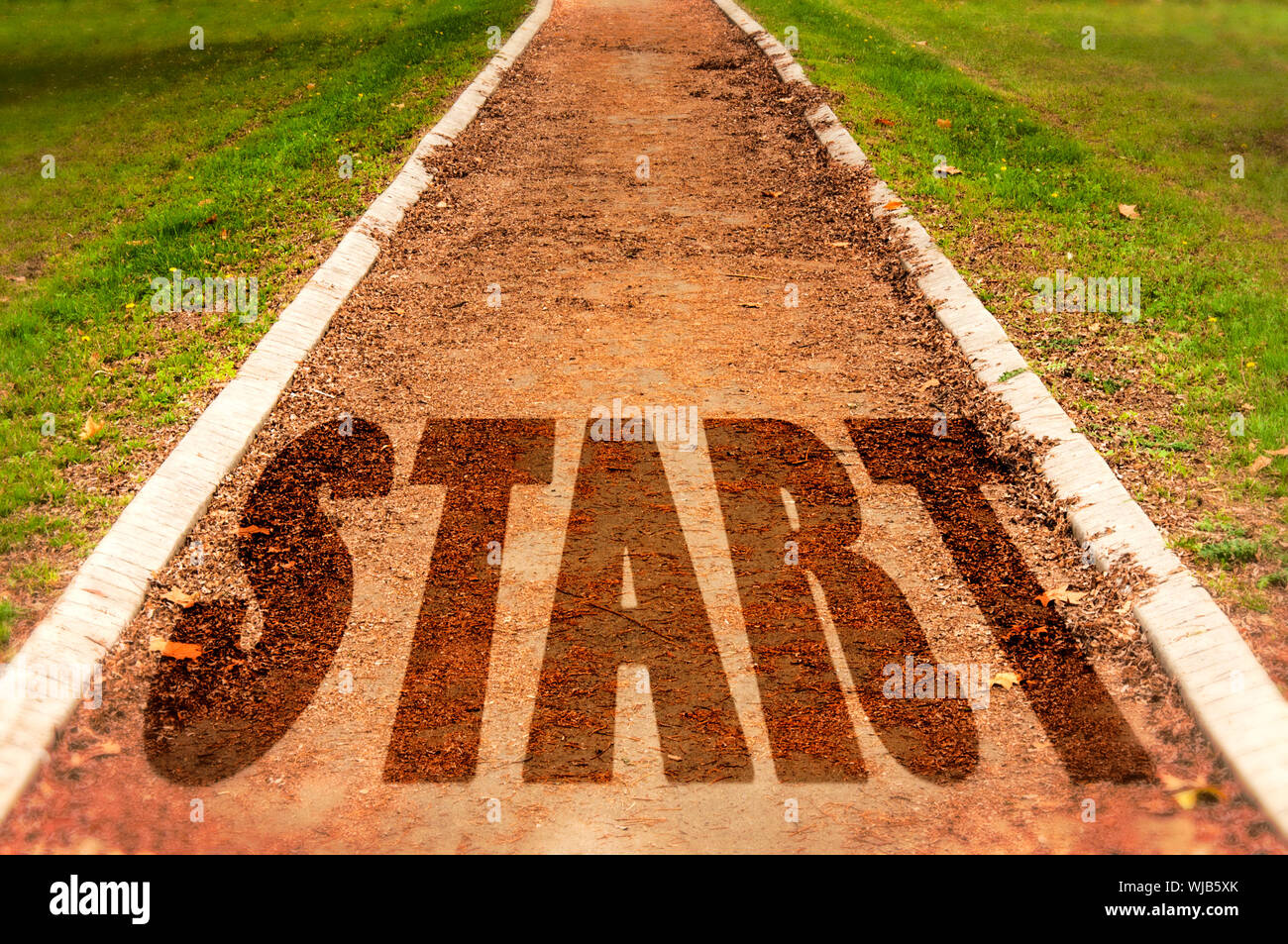 Start on running track with grass and leafs Stock Photo - Alamy