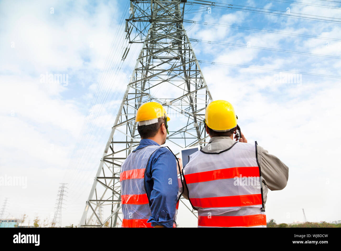 two workers wearing protective helmet works at electrical power station ...