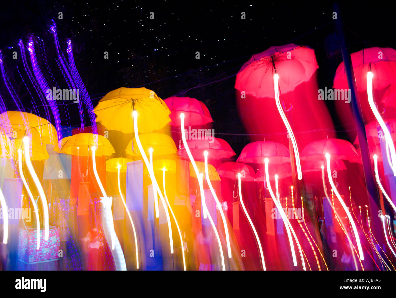 speed of umbrellas neon light in the night sky Stock Photo - Alamy