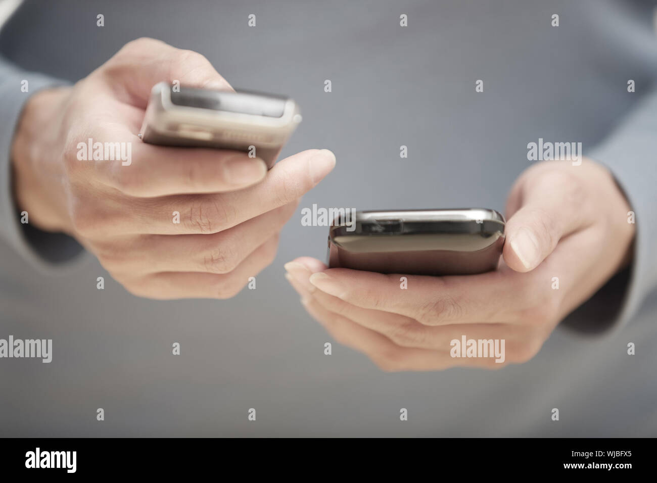 Human hands using two smartphones for data transfer Stock Photo - Alamy