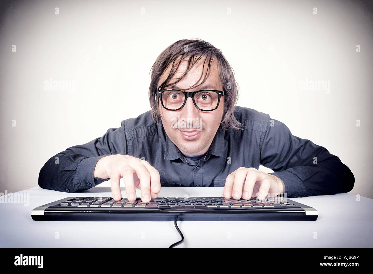 Hacker typing on the keyboard and mocking Stock Photo - Alamy