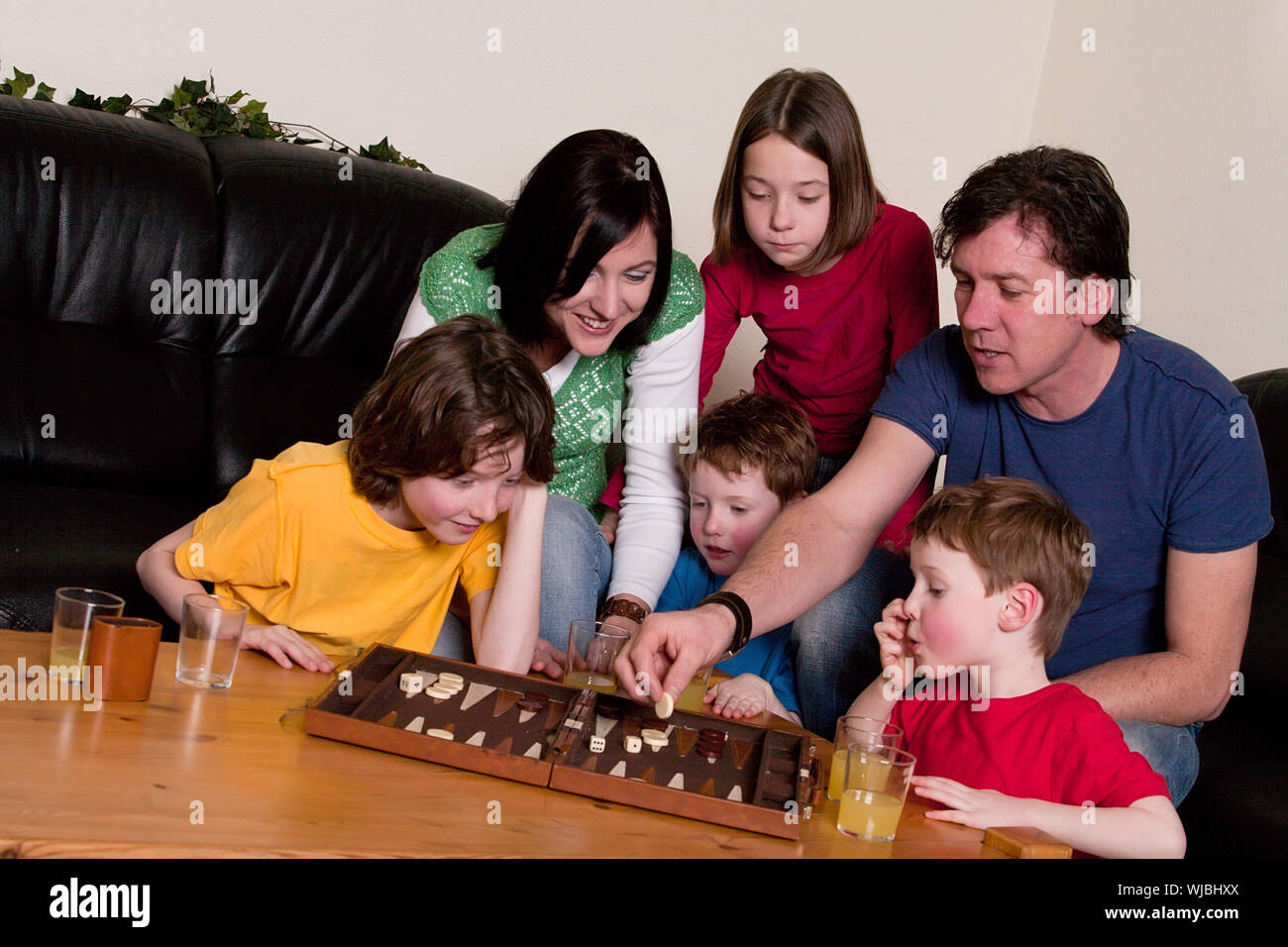 Big family is playing a boardgame in the livingroom Stock Photo - Alamy