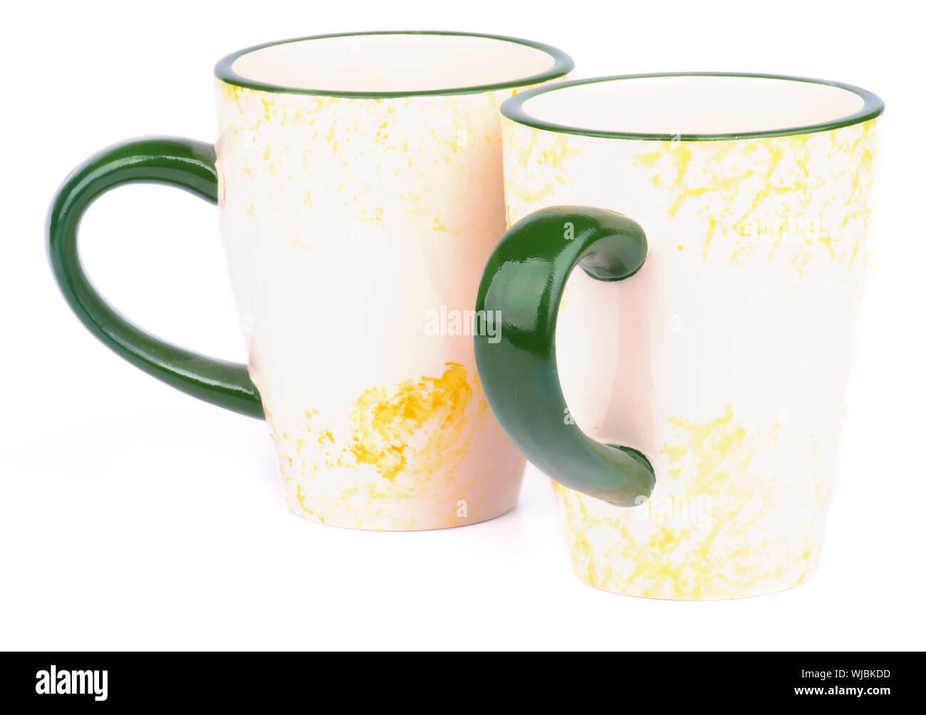 Pair of Beige Tea Cups with Green Handles isolated on white background ...