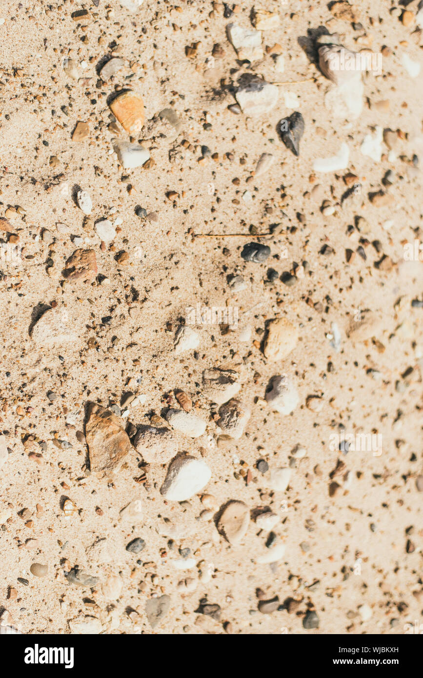 Sand and smooth stones on the beach. Sandy texture, coast, river bank ...