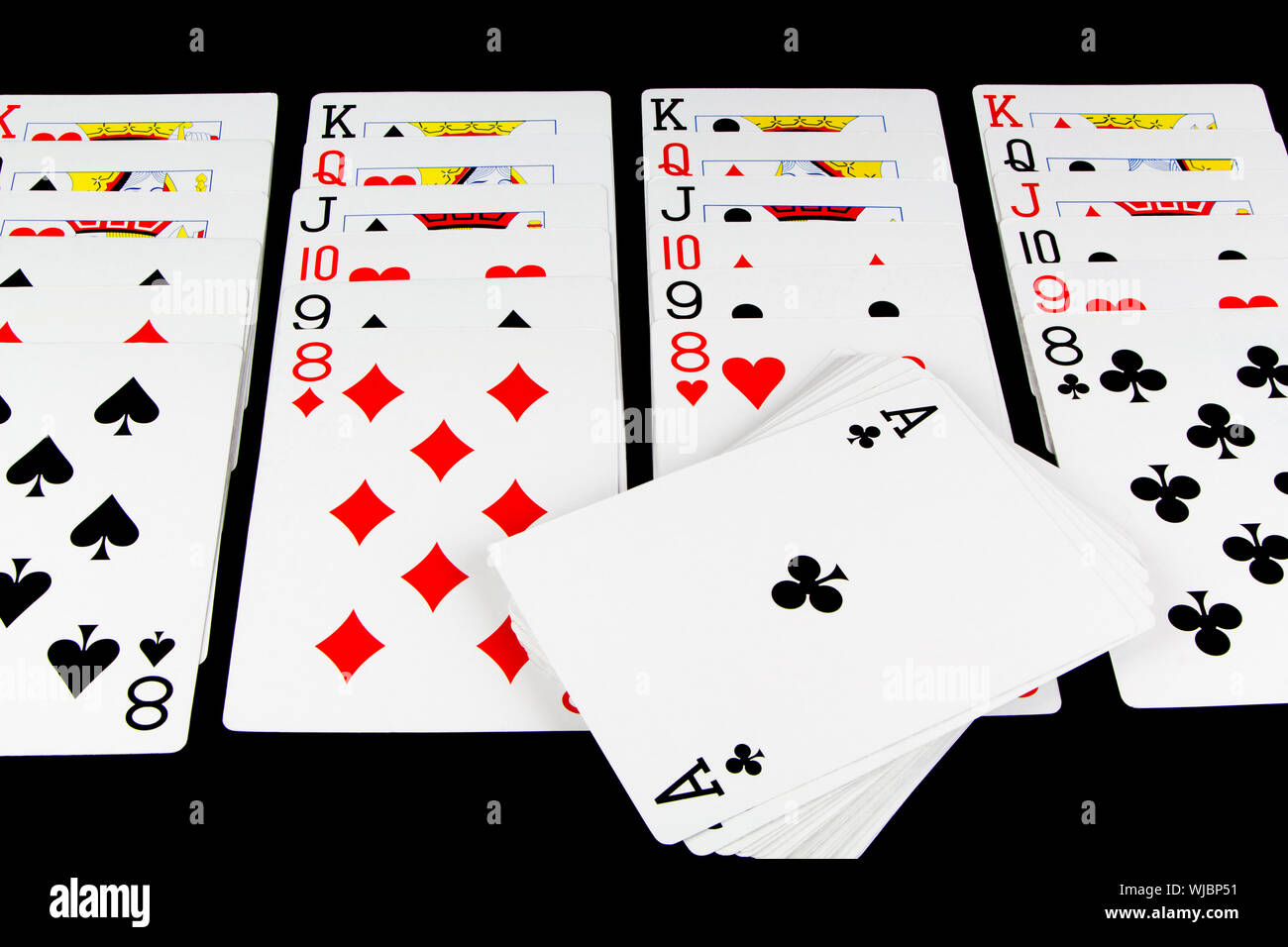 Playing cards being used for solitaire on black background Stock Photo ...