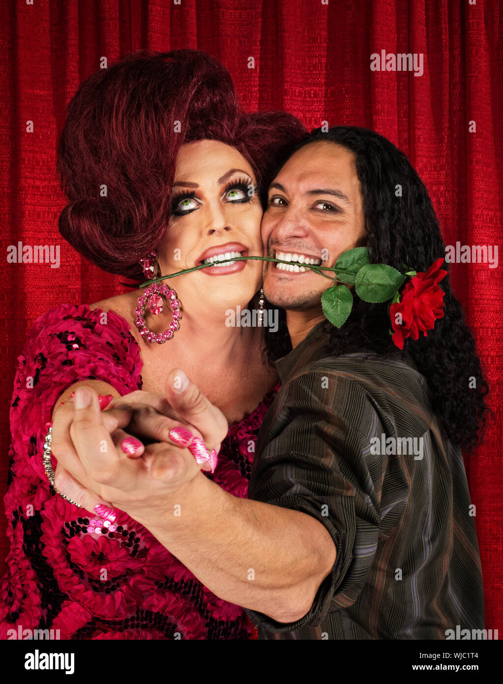 Happy eccentric dancing couple with rose in mouth Stock Photo - Alamy