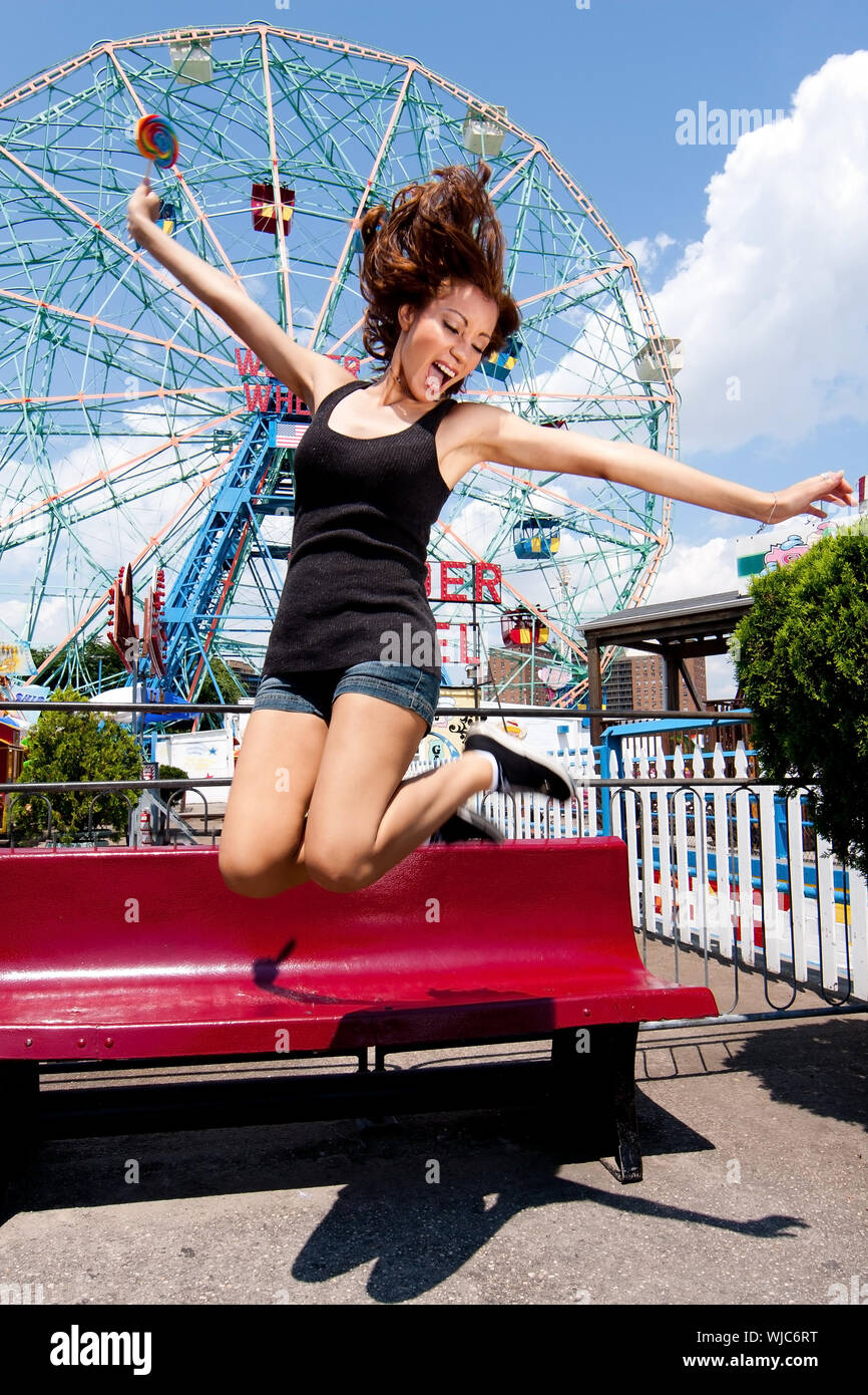 Beautiful fun happy girl jumping with colorful lollipop at the Wonder ...