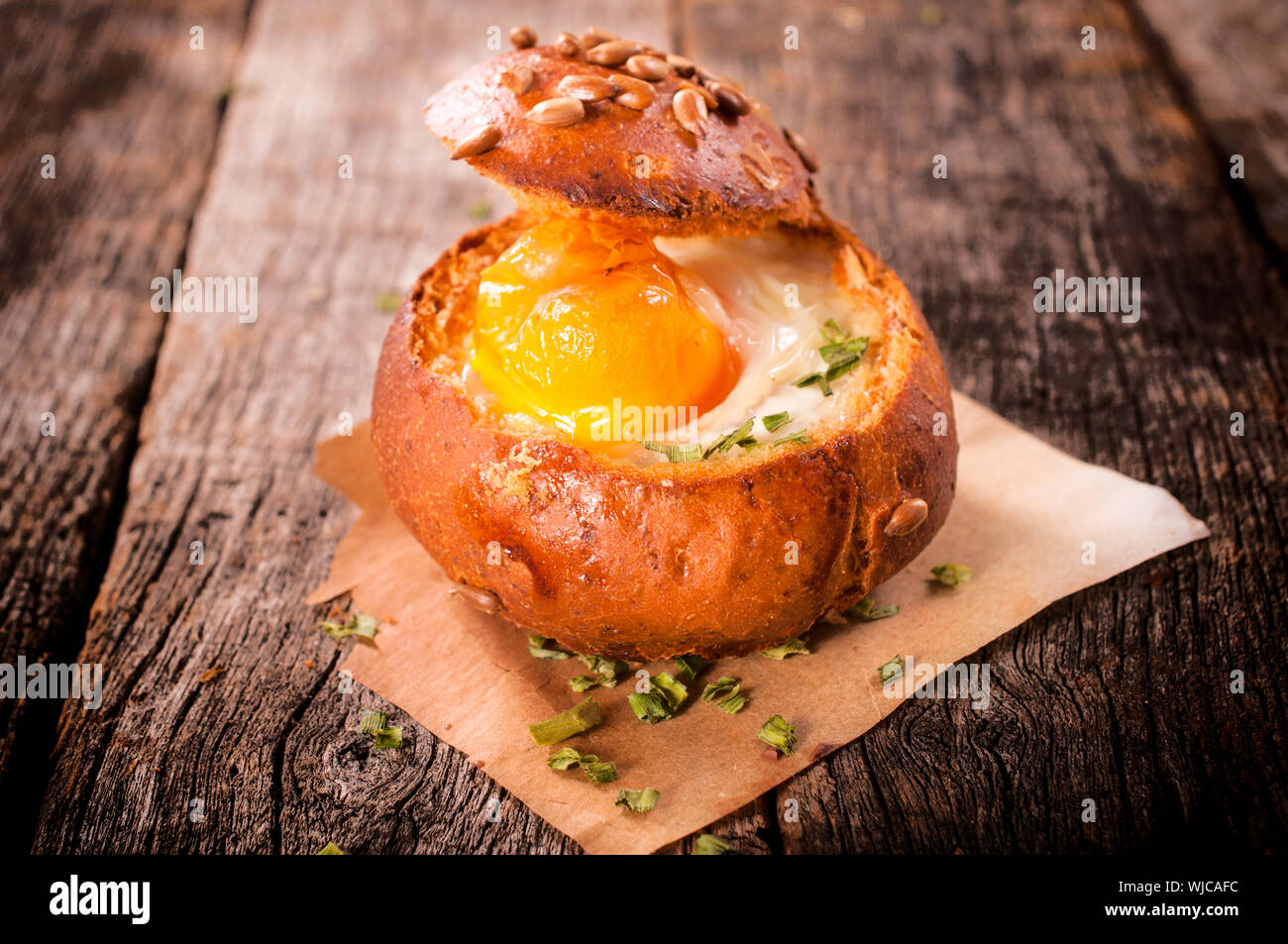 Single bun stuffed with the baked egg Stock Photo - Alamy