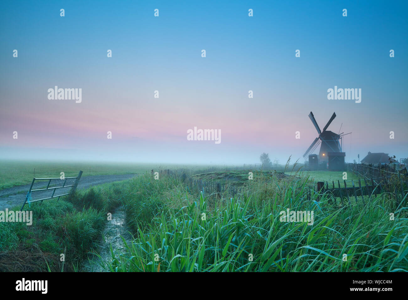 sunrise over Dutch farmland with windmill, Holland Stock Photo - Alamy