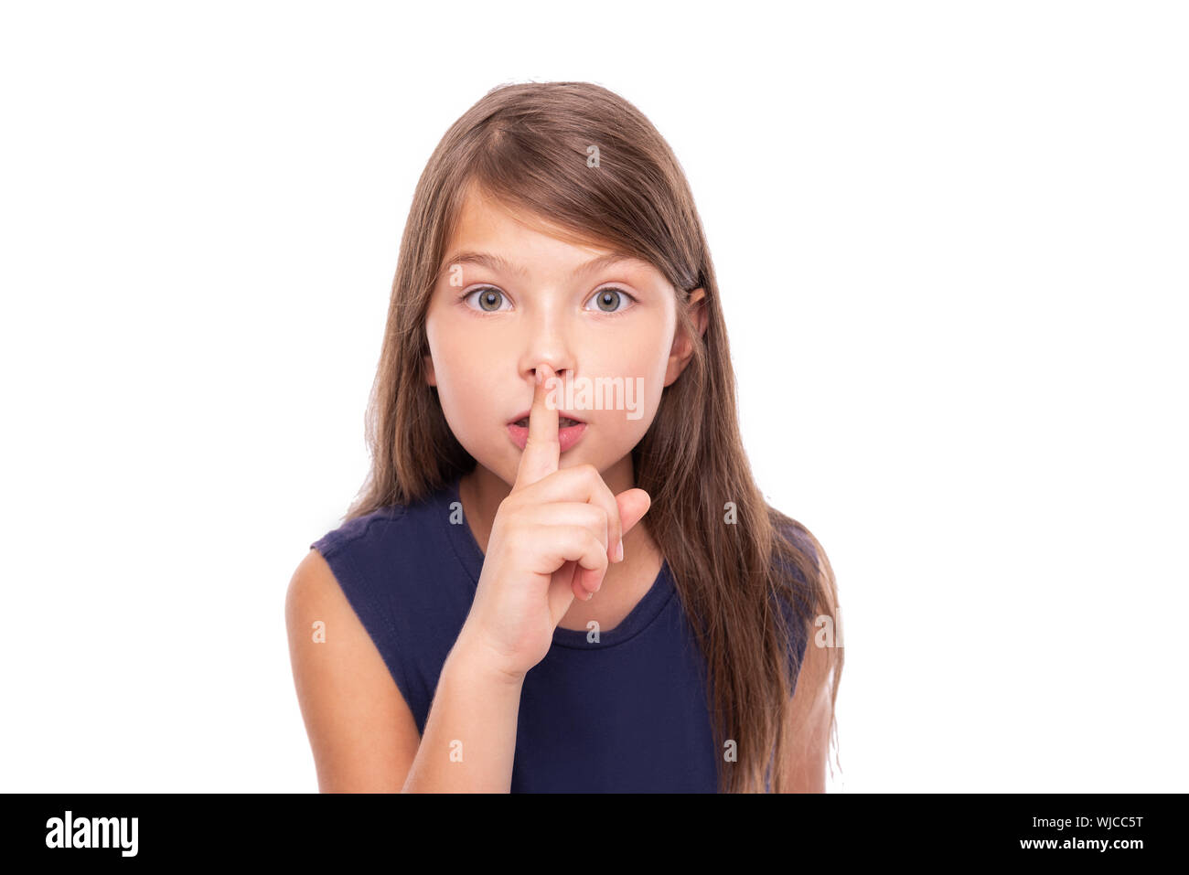 Little girl presses her finger to her lips Stock Photo - Alamy
