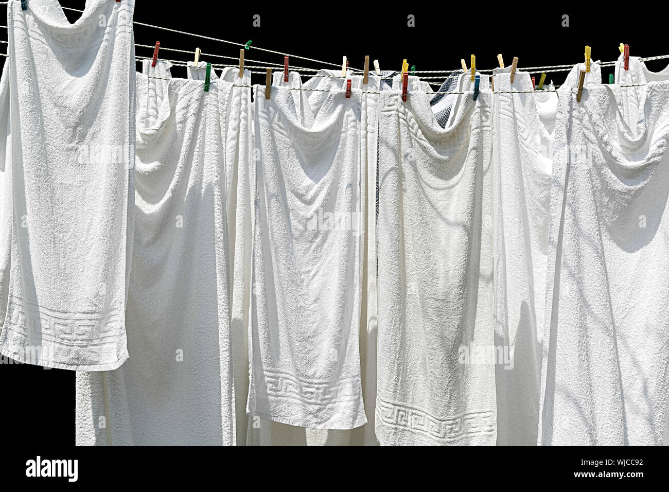 white towels hanging on clothesline isolated on black Stock Photo - Alamy