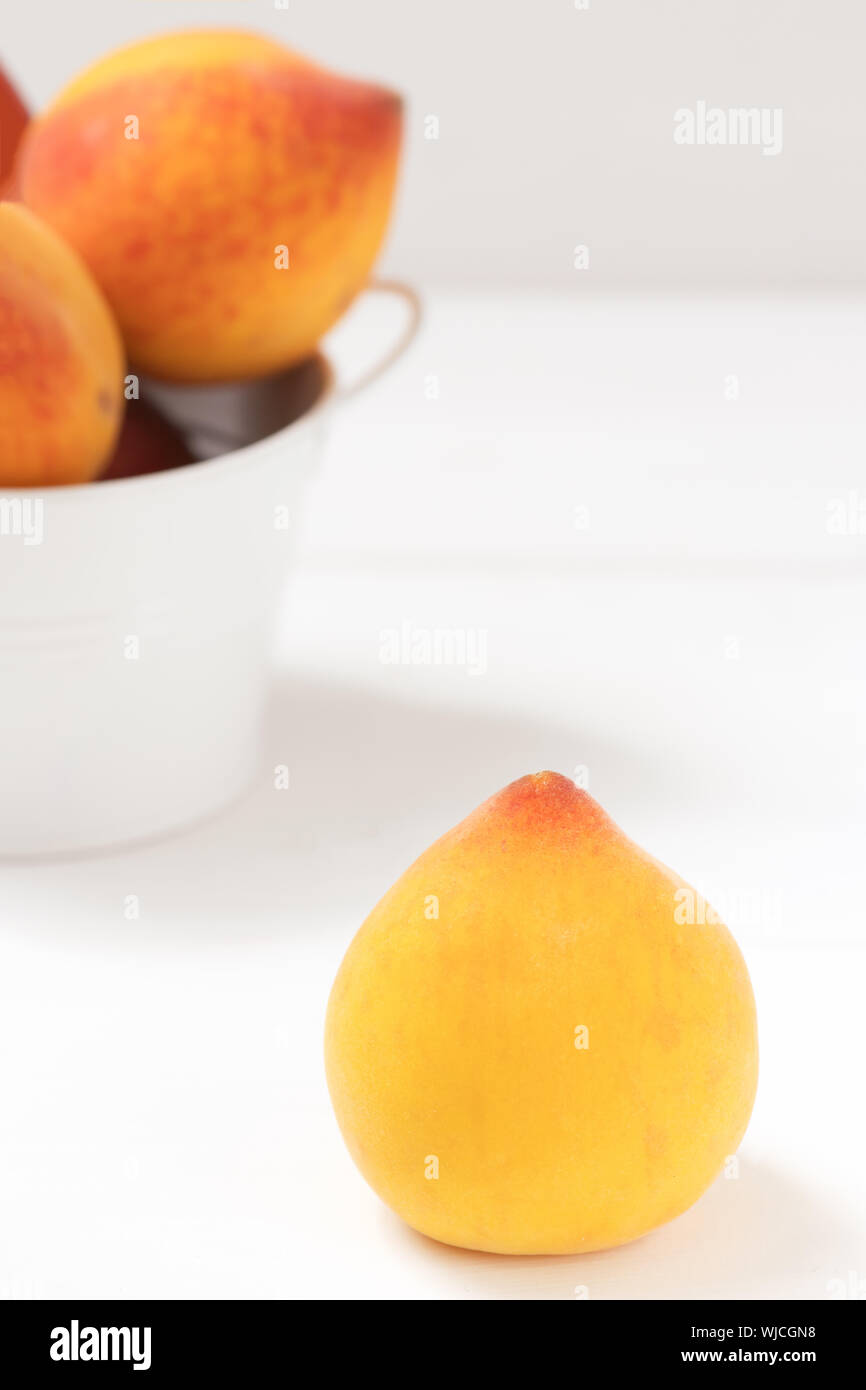 Yellow italian fresh peach percoche in a white bucket on the white ...