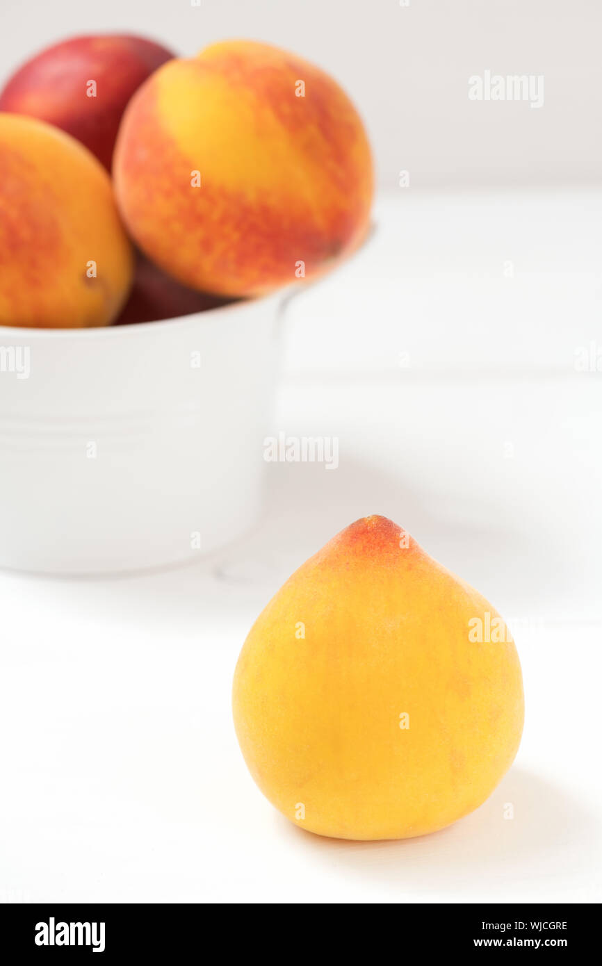 Yellow italian fresh peach percoche on the white wooden background with ...