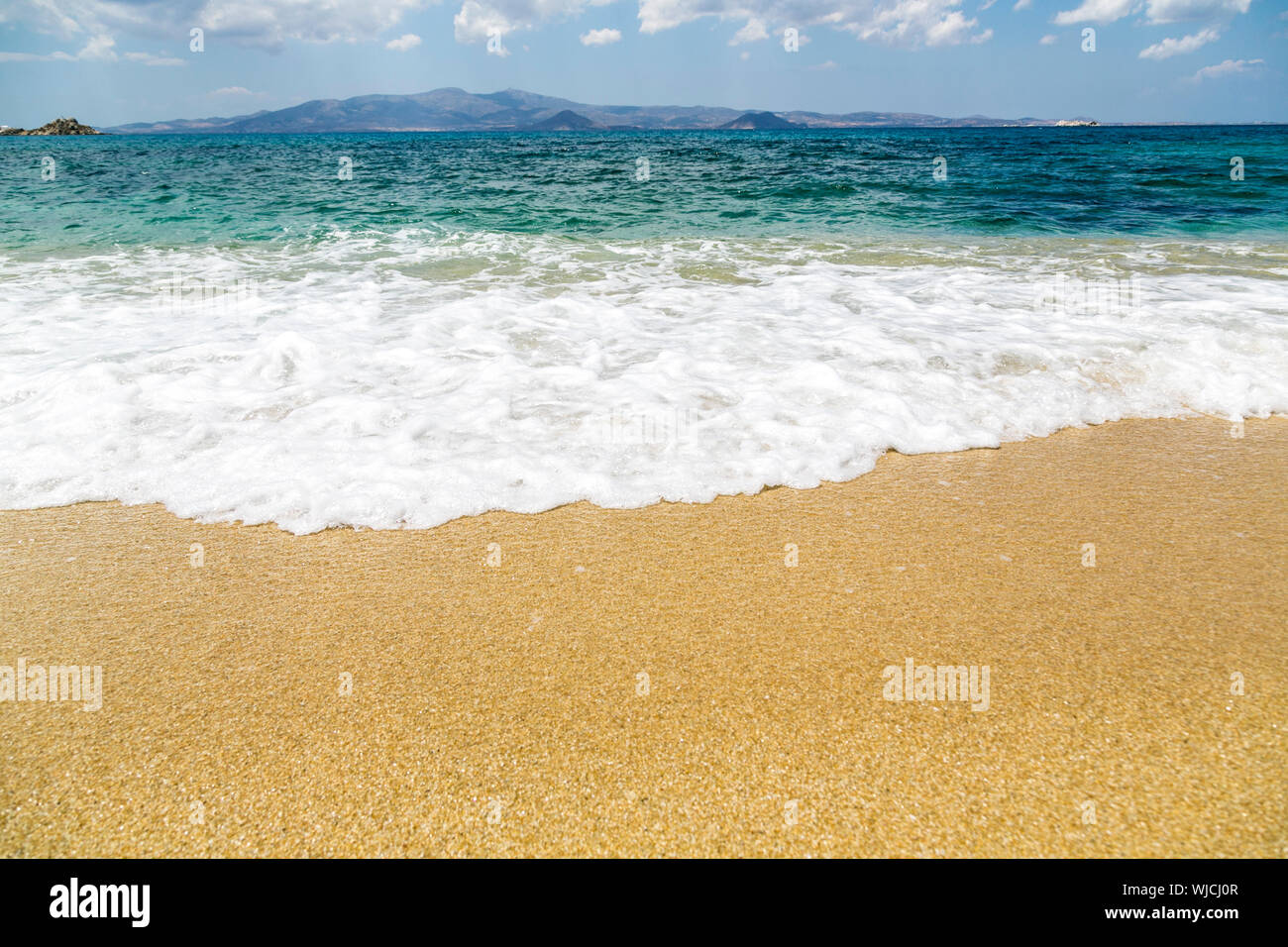 ocean with island in background and froth Stock Photo - Alamy
