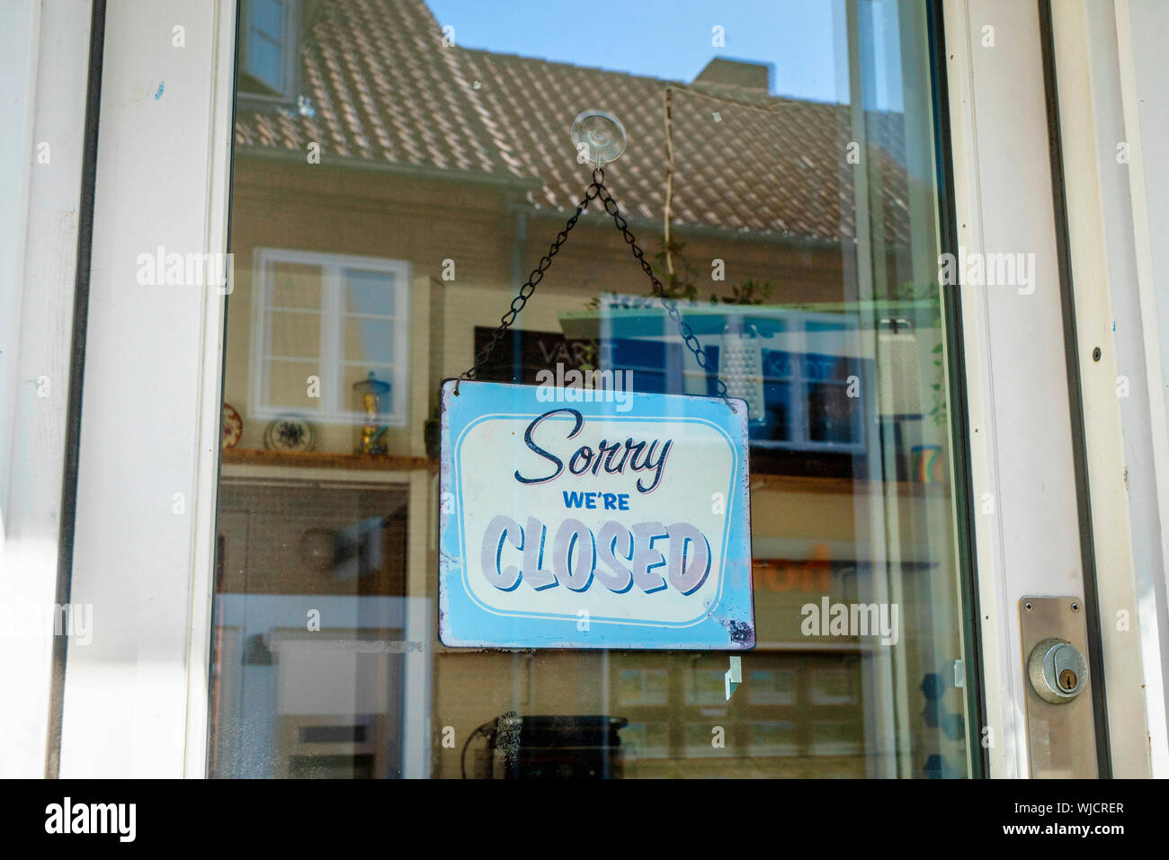 Closed sign hanging in a store window on a city street with a retro ...