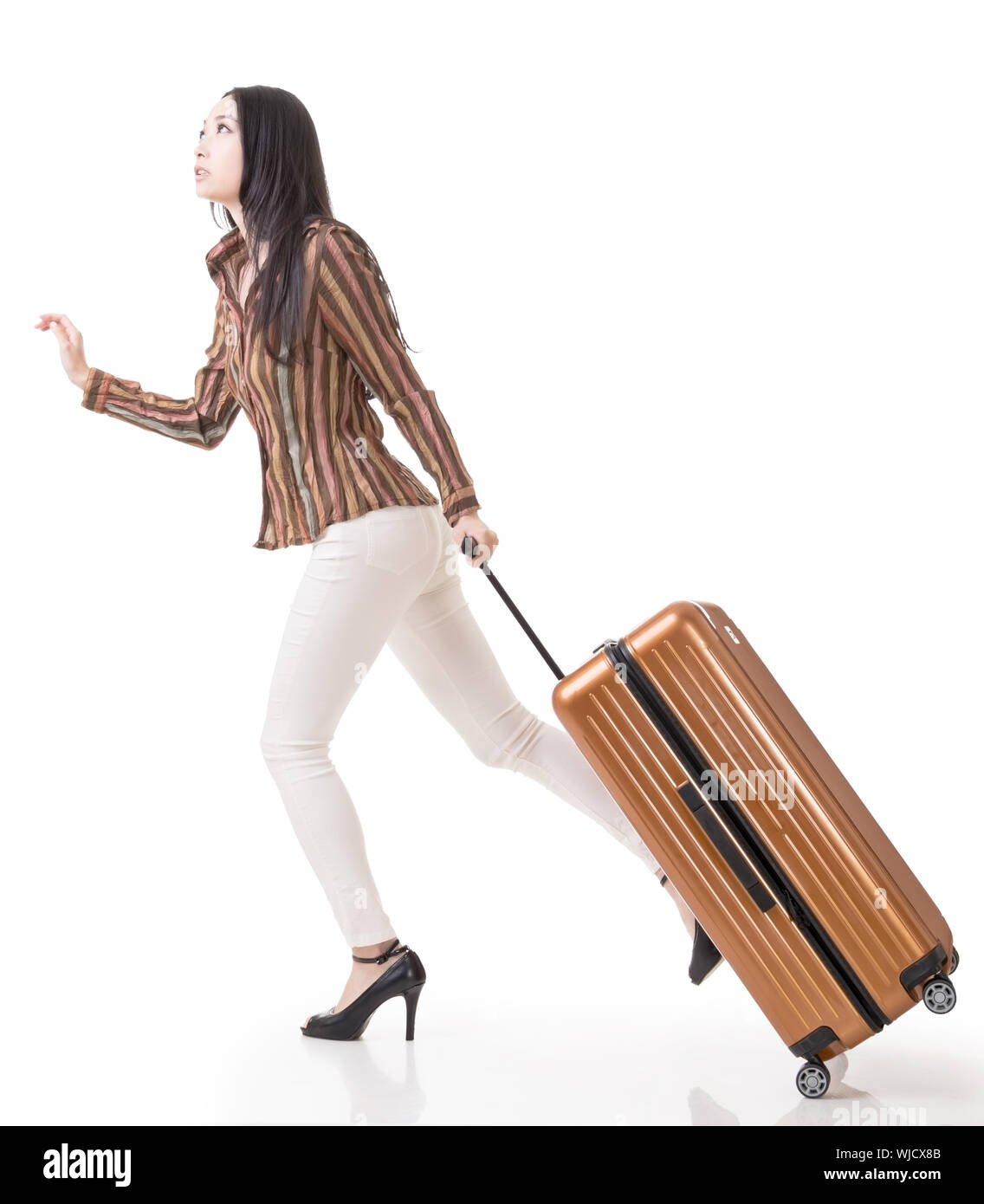 Modern Asian woman running and holding a suitcase, side view full ...