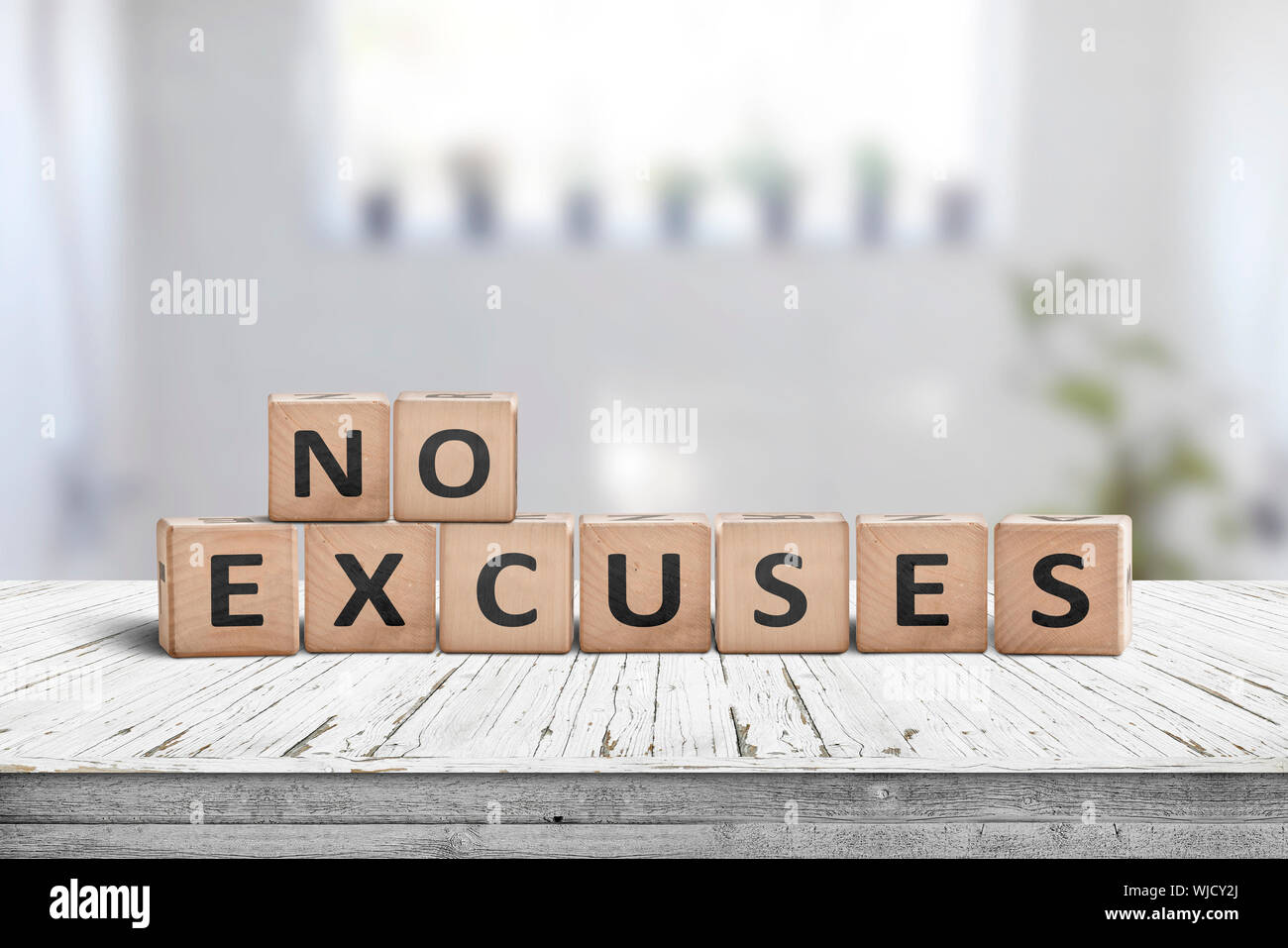 No excuses sign in a bright room on a wooden table with worn planks ...