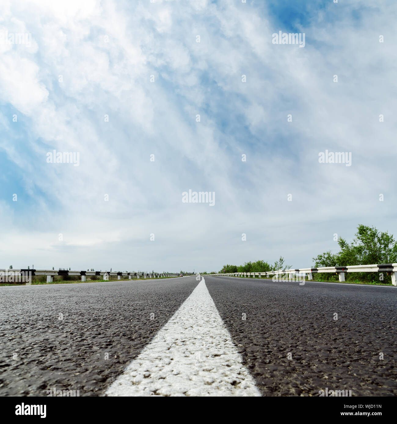 white line on asphalt road and clouds over it Stock Photo - Alamy