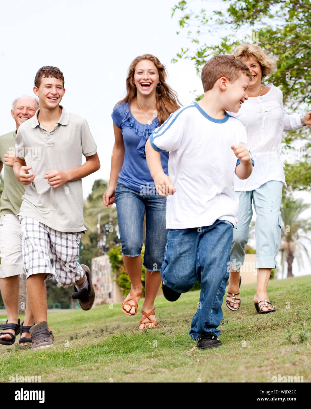 Happy young family chasing young kid in the park and having fun Stock ...