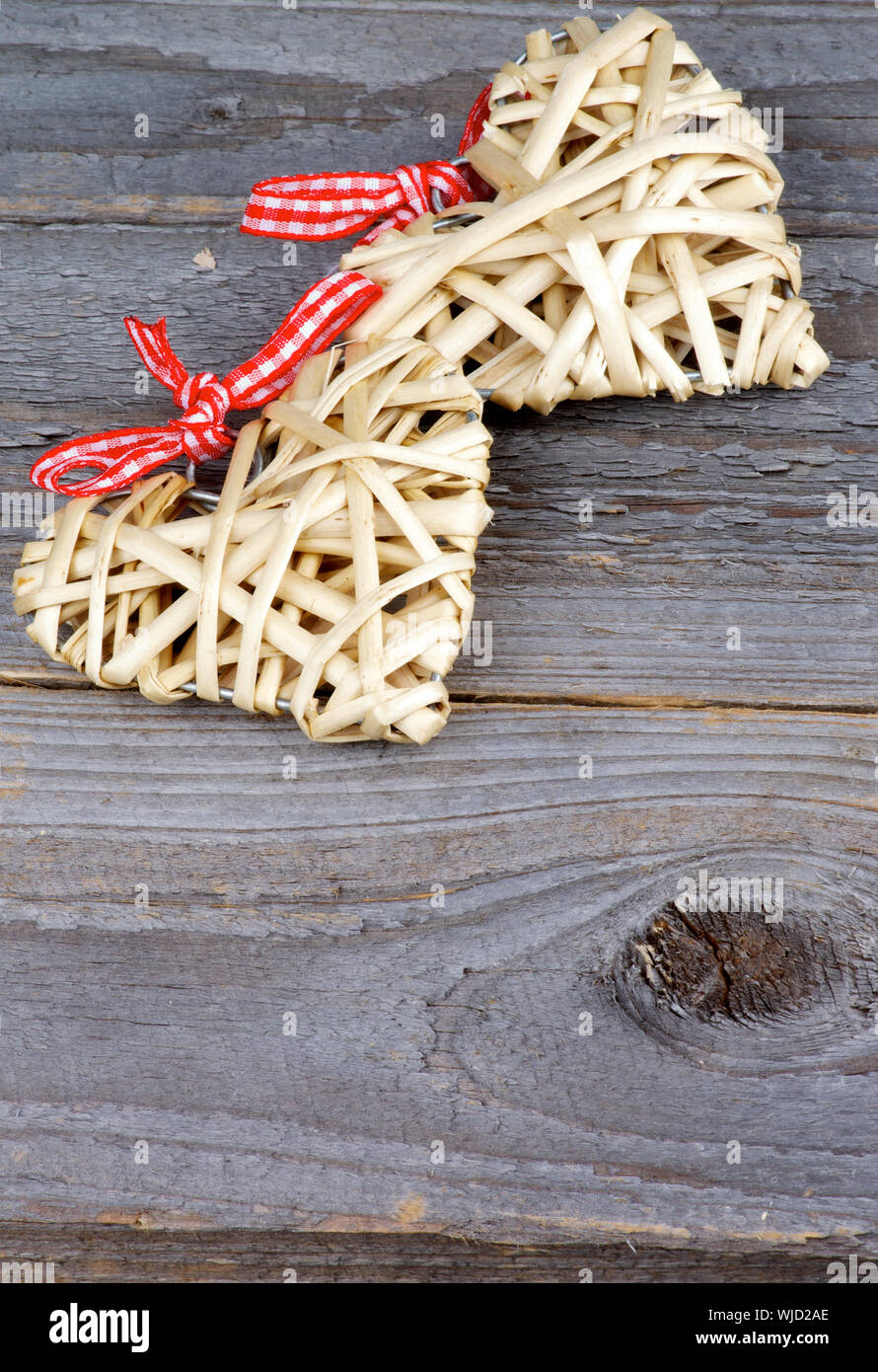 Two Handmade Wicker Hearts with Red Checkered Bows isolated on Rustic ...