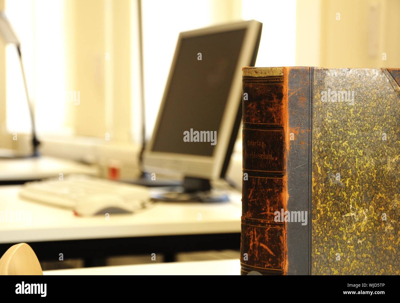 old books and computer on a desk in a library Stock Photo - Alamy