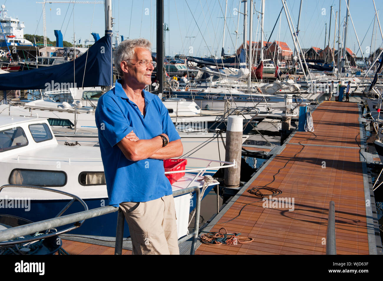 elderly retired man resting in harbor with sail and motor boats Stock ...