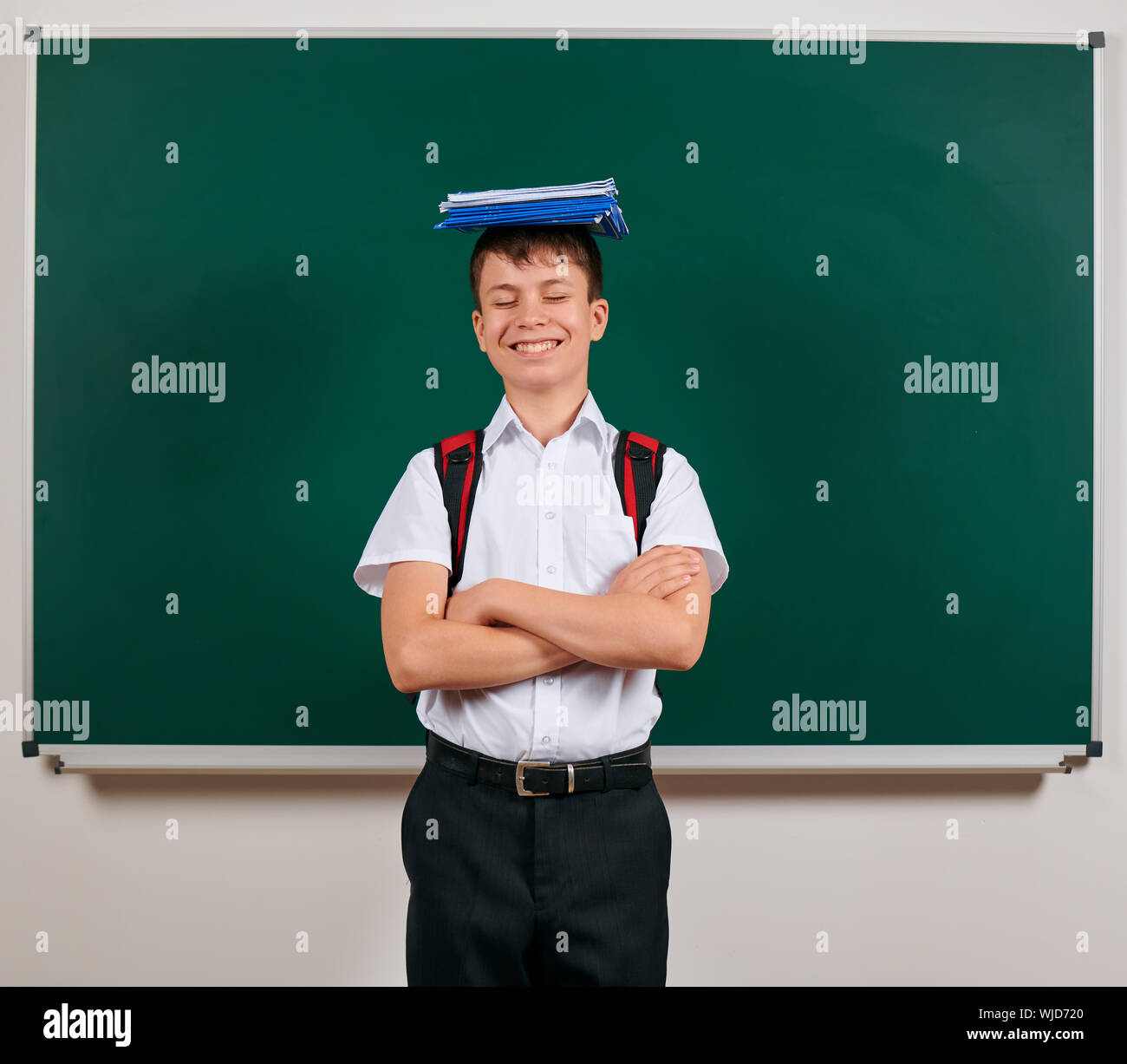 Portrait of a school boy posing with backpack and school supplies ...