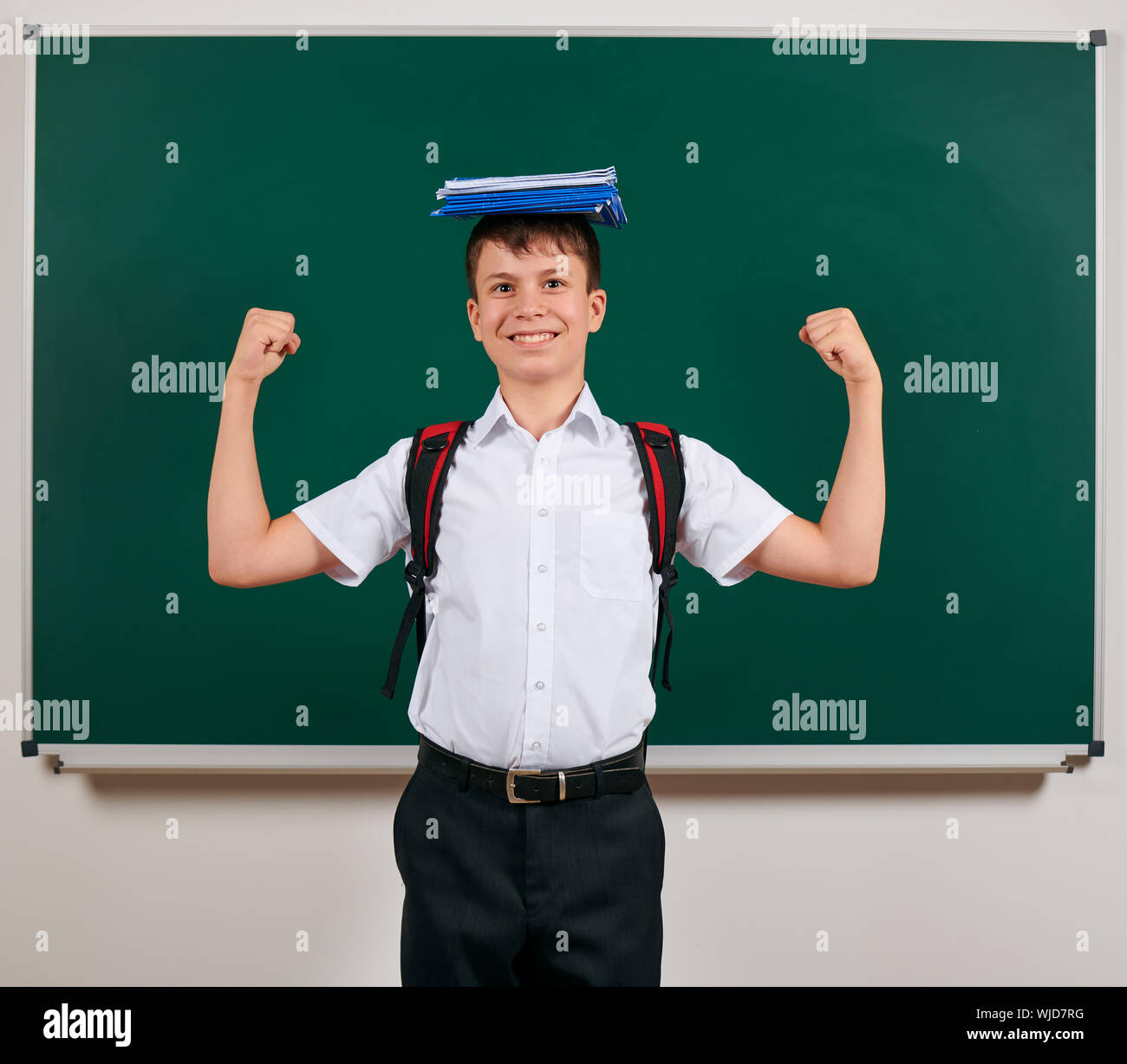 Portrait of a school boy posing with backpack and school supplies ...