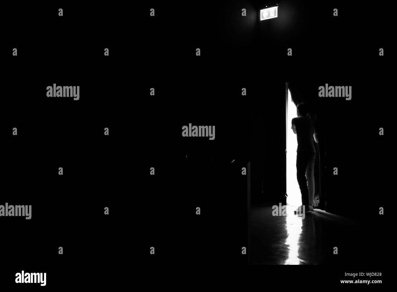 Exit sign man standing Black and White Stock Photos & Images - Alamy
