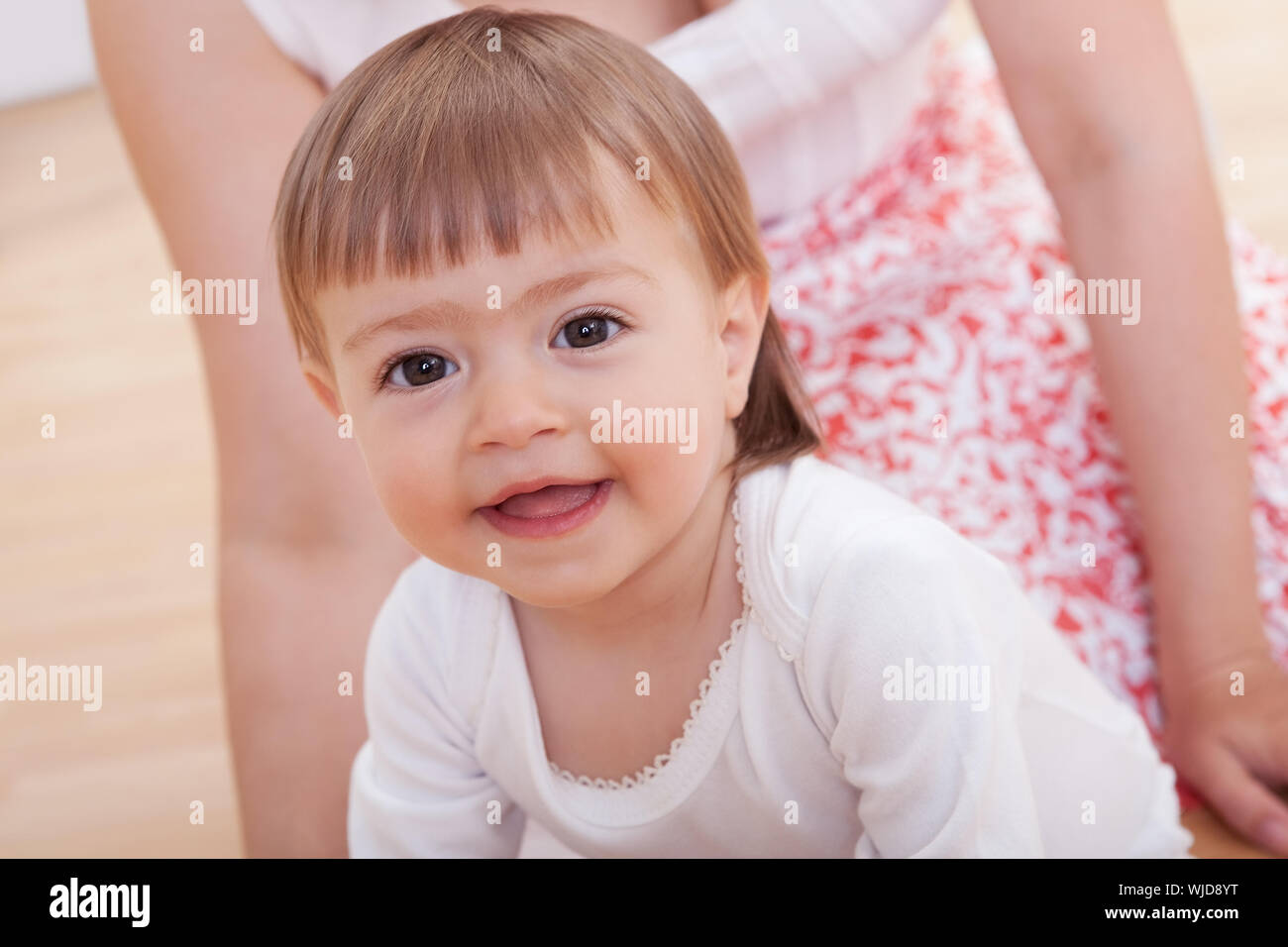 Portrait of a cute innocent young baby smiling and looking with love ...