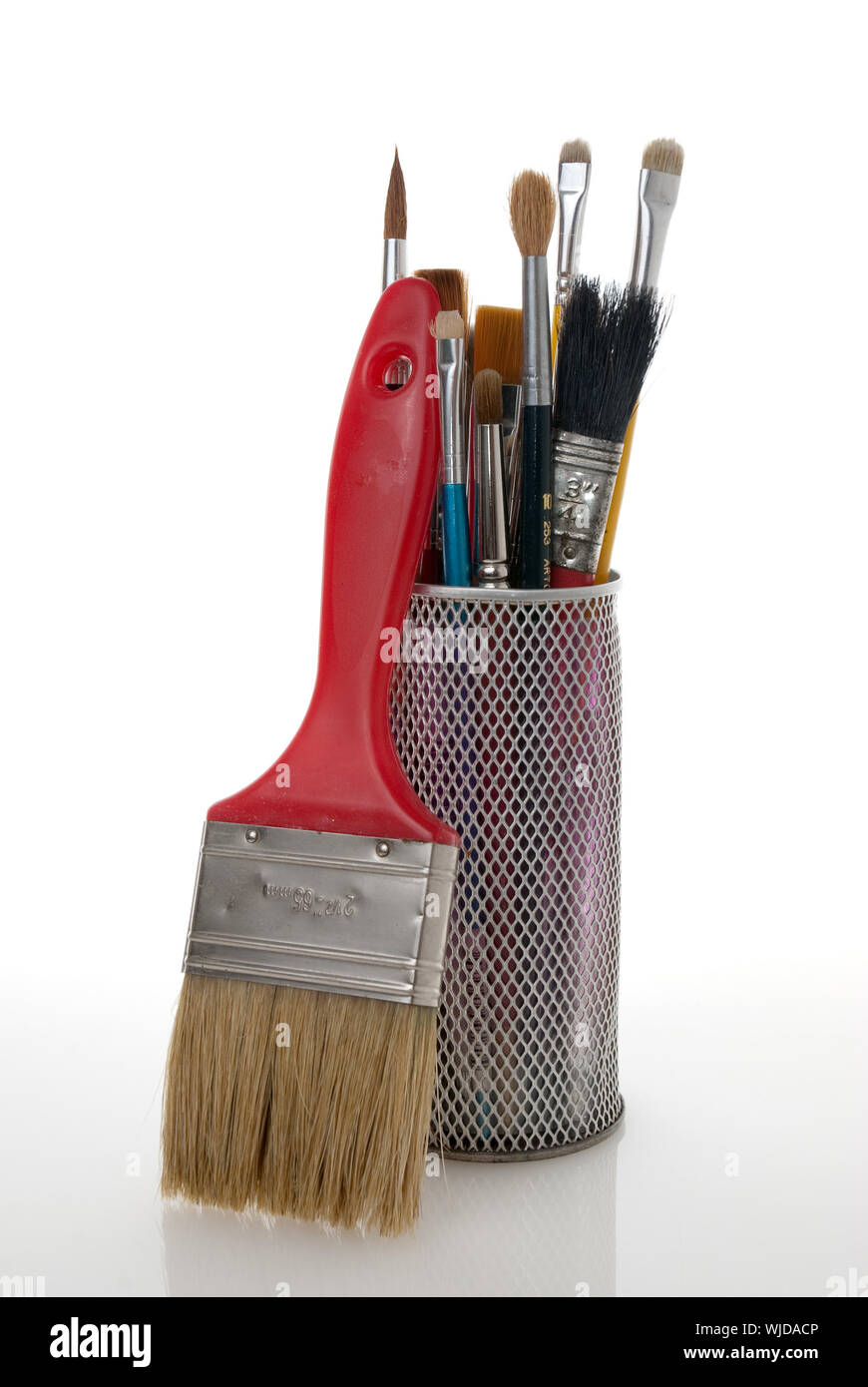 Paintbrushes in a metal mesh holder on white background Stock Photo - Alamy