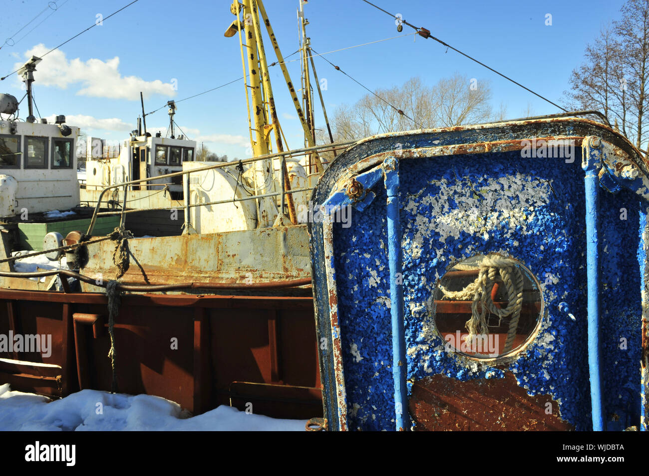 Blue, rusty door of the aged ship with a window. Navigation is closed ...