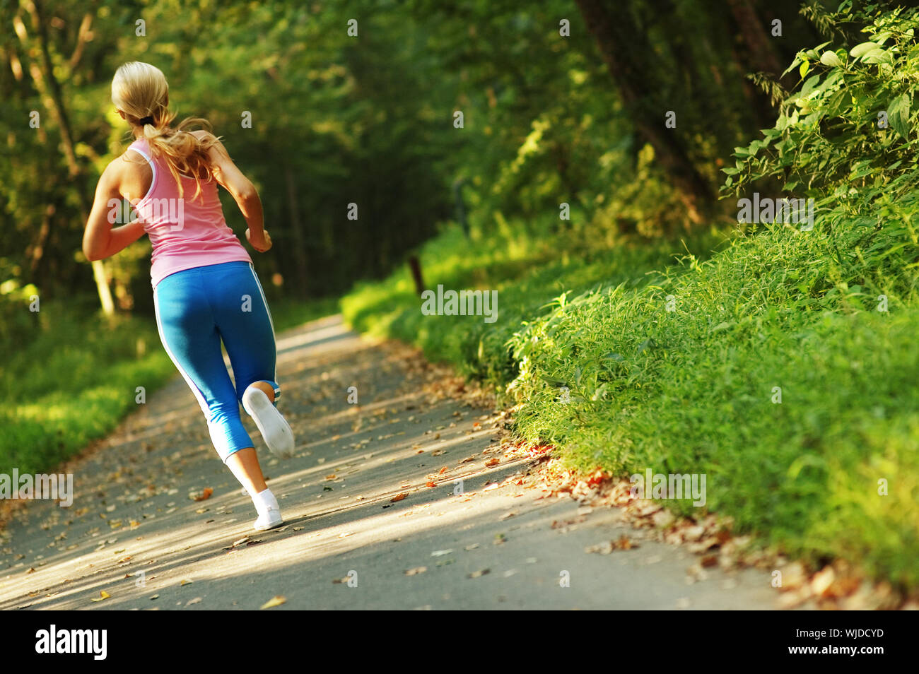 Pretty young girl runner in the forest Stock Photo - Alamy
